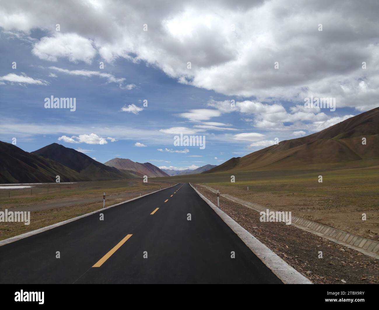 An aerial view of a deserted two-lane road that stretches across a wide ...