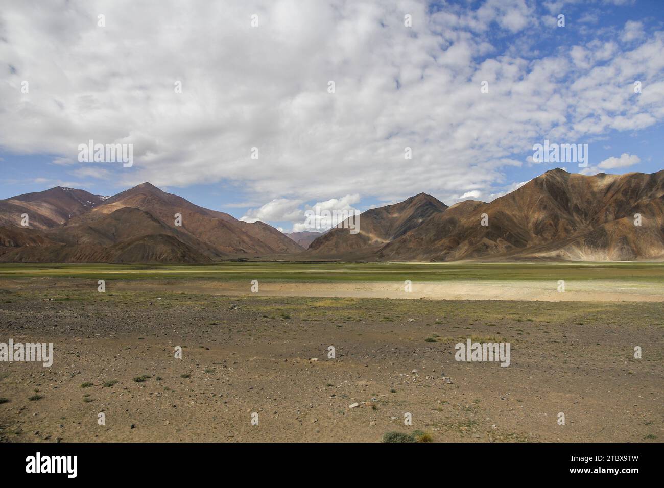 This stock photo depicts a sweeping expanse of desert terrain, with a ...