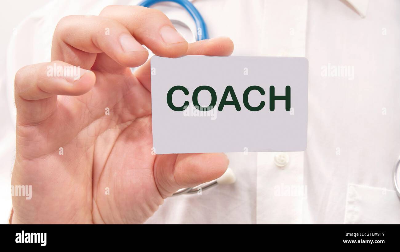 COACH word on the card in a man's hand on the background of a white ...