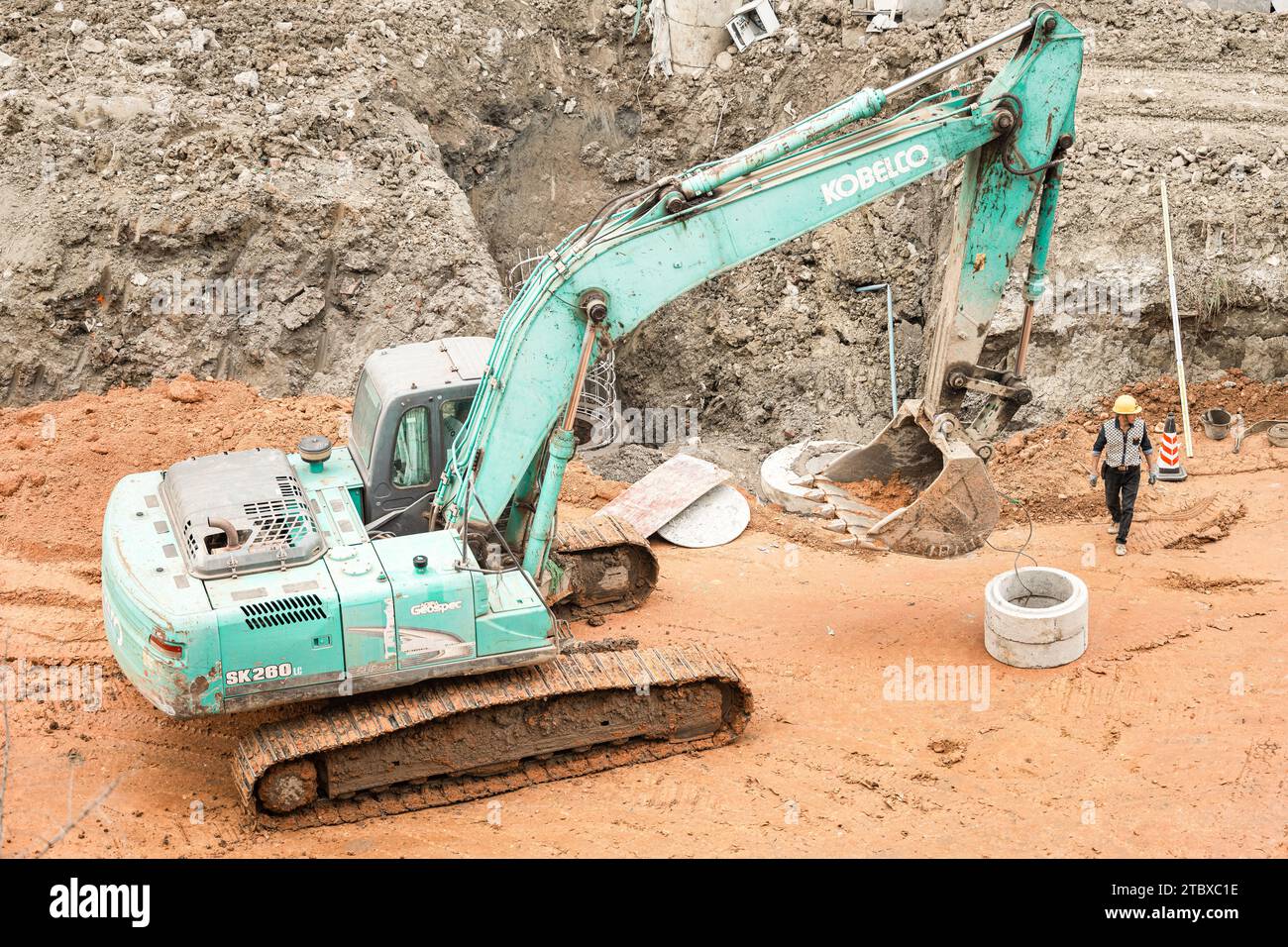 Excavator digging soil inside construction site Stock Photo - Alamy
