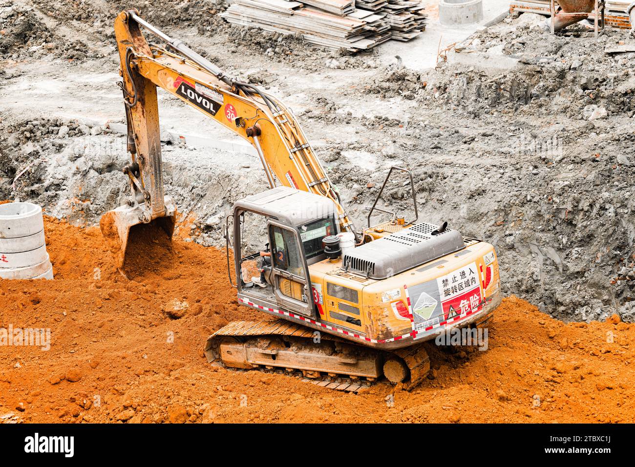 Excavator digging soil inside construction site Stock Photo - Alamy