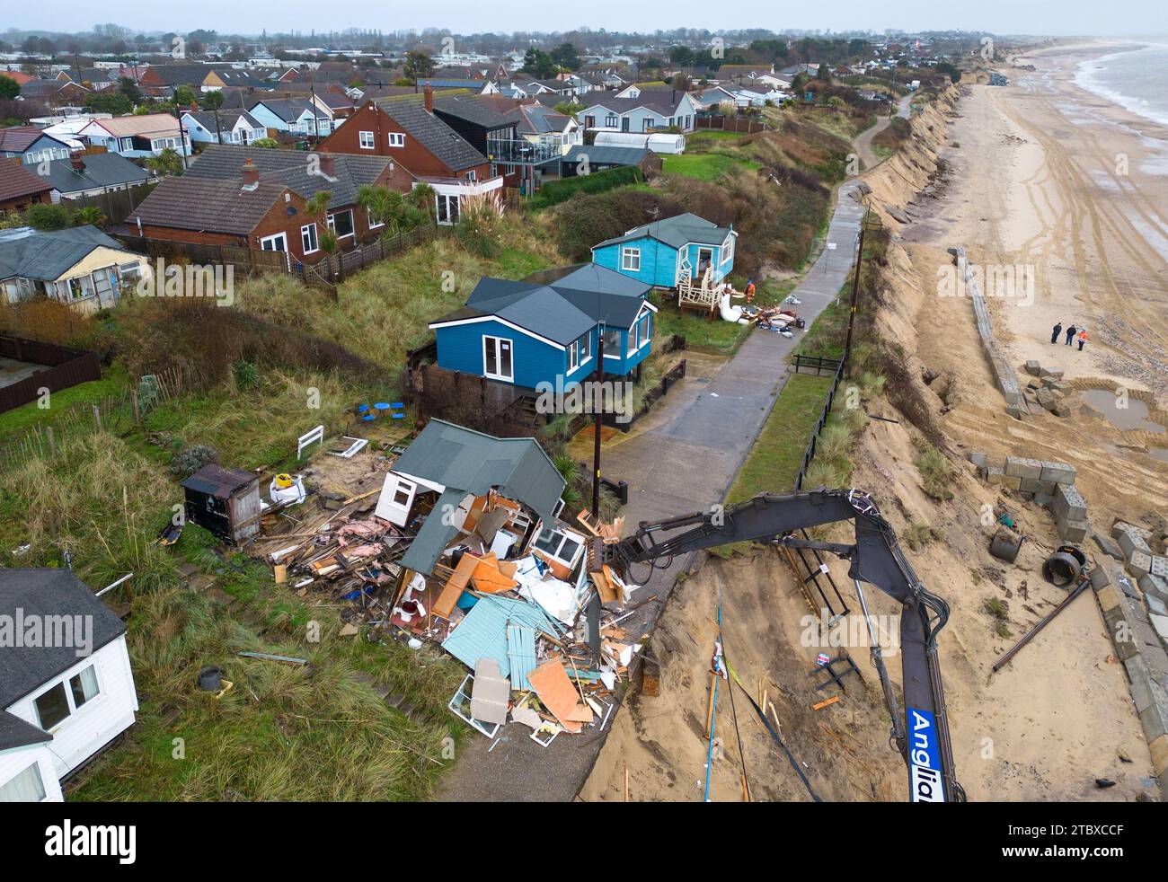 Demolition workers tear down the first of five clifftop homes in the ...