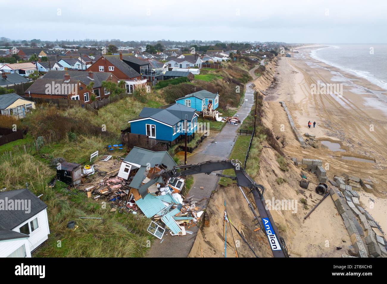 Demolition workers tear down the first of five clifftop homes in the ...