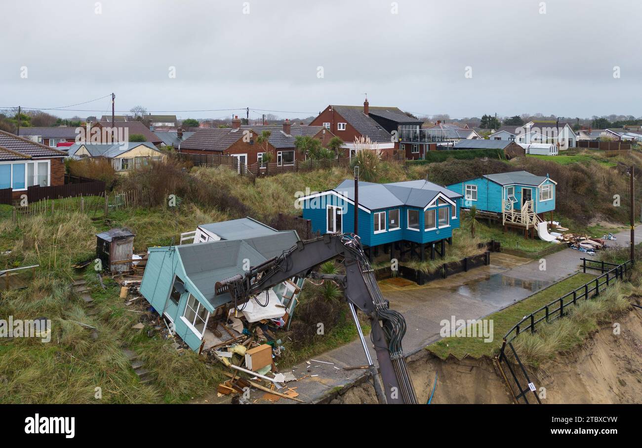 Demolition workers tear down the first of five clifftop homes in the ...