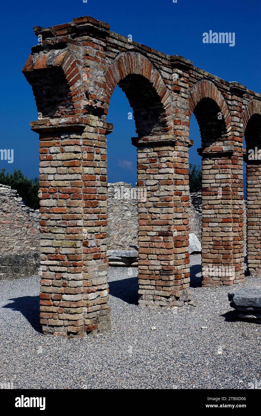 Brick arcade under a blue summer sky at the Grotte di Catullo or ...