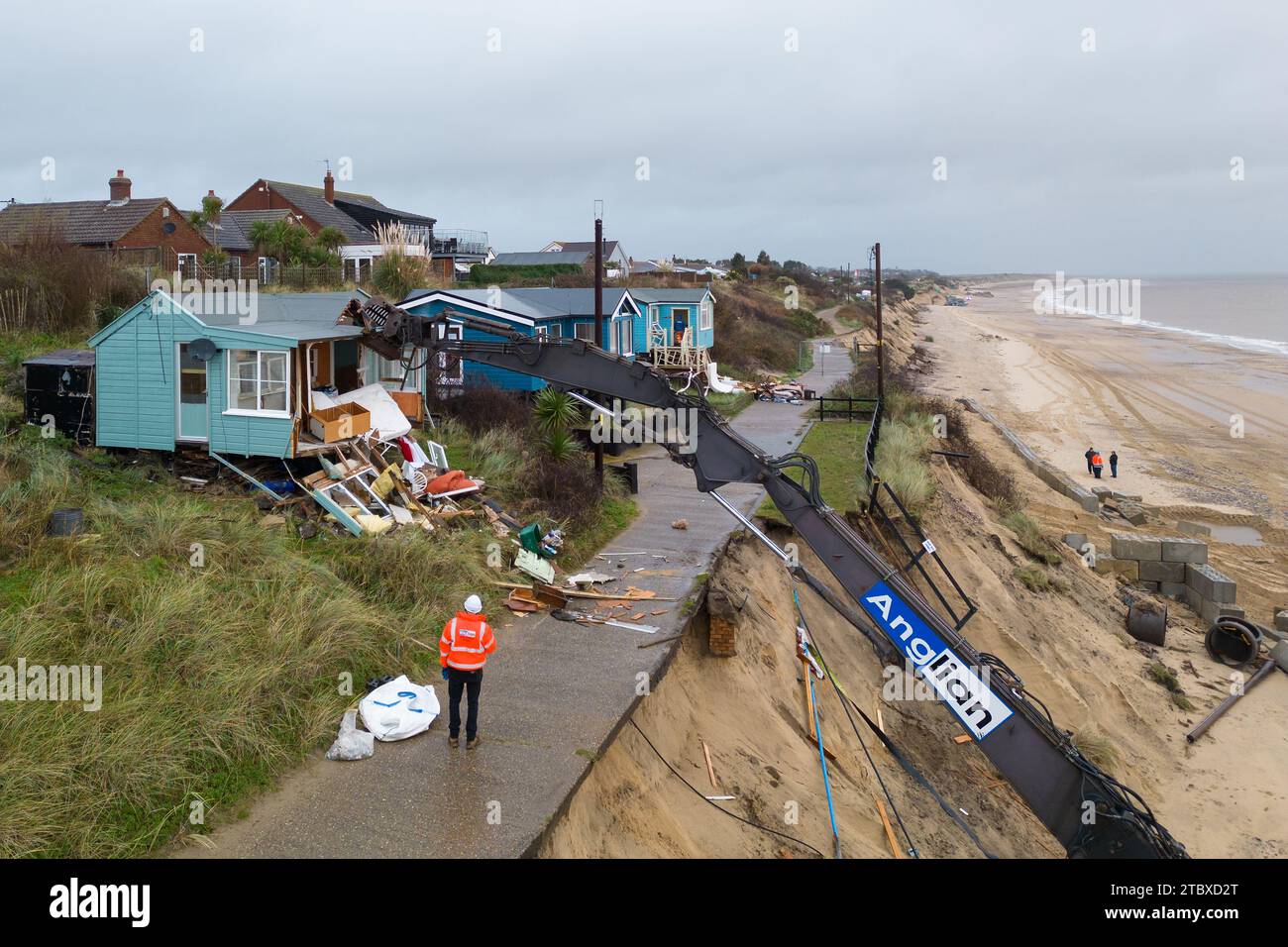 Demolition workers tear down the first of five clifftop homes in the ...
