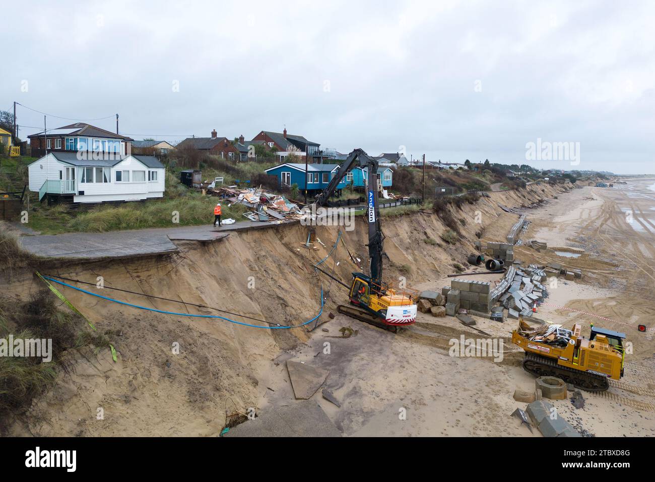 Demolition workers tear down the first of five clifftop homes in the ...