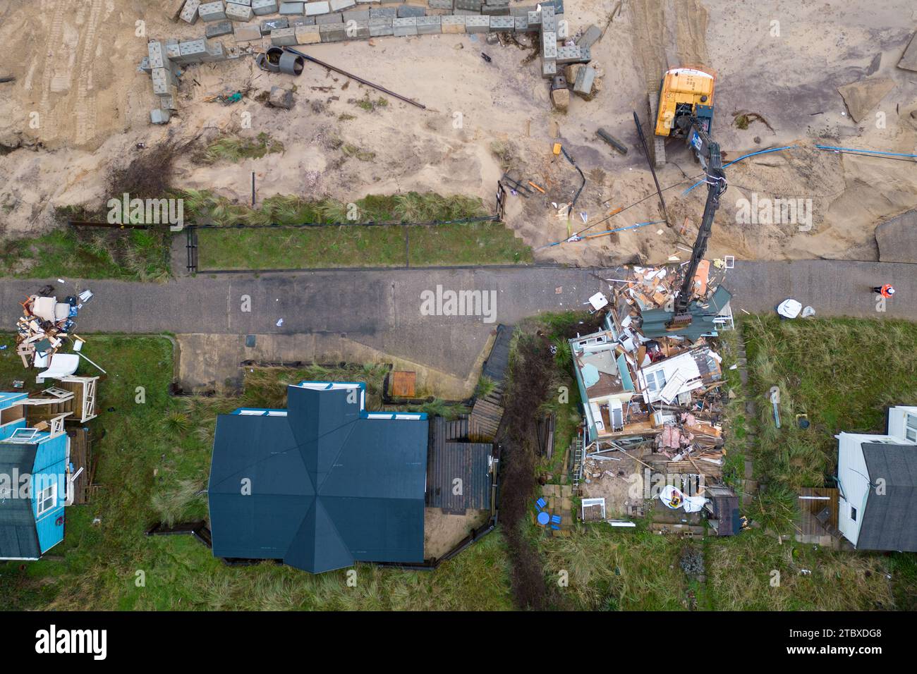 Demolition workers tear down the first of five clifftop homes in the ...