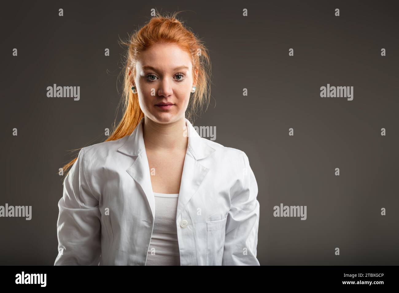 Technical specialist in a lab coat stands with determination, her red ...