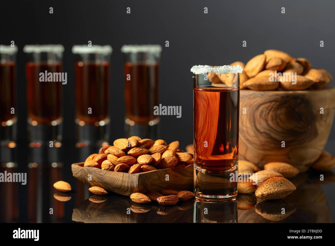 Strong alcoholic Italian liqueur Amaretto with almonds nuts on a black ...