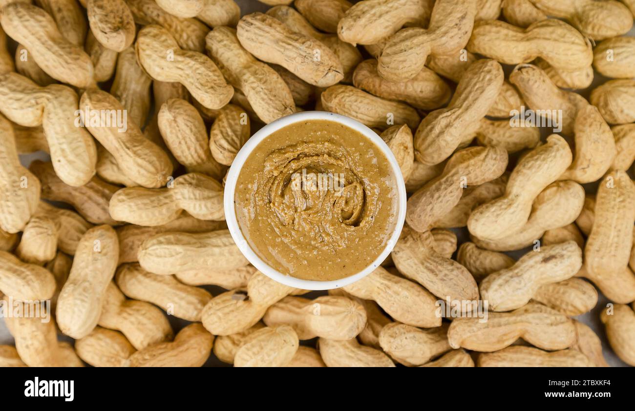 Peanut butter on the background of peanuts, top view Stock Photo - Alamy