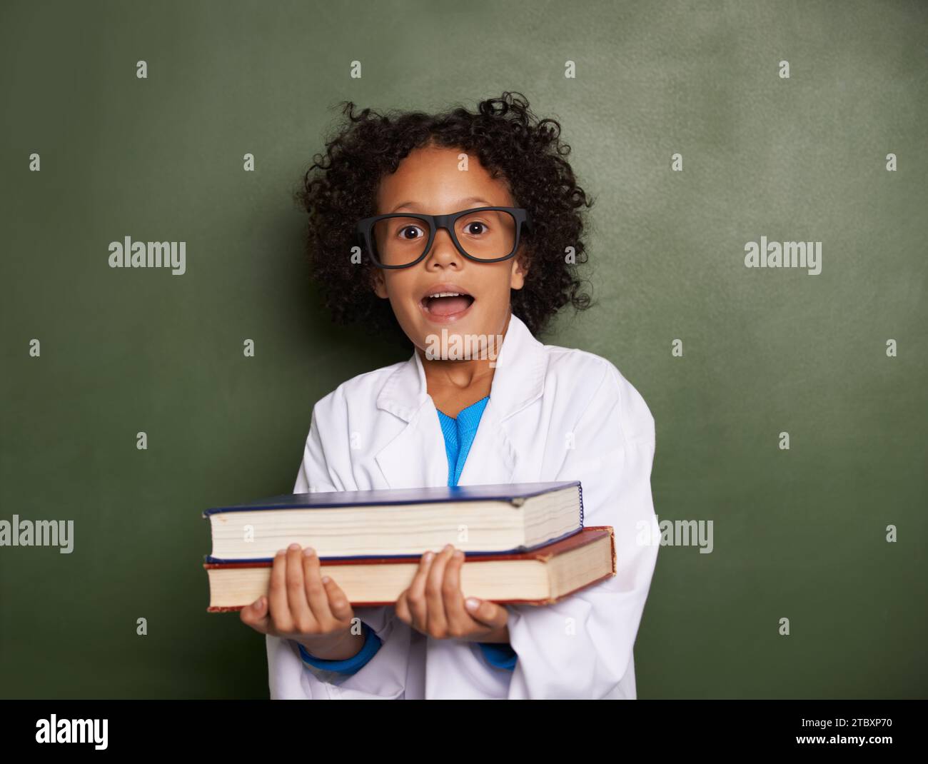 Child, surprise and portrait with books by chalkboard for education ...
