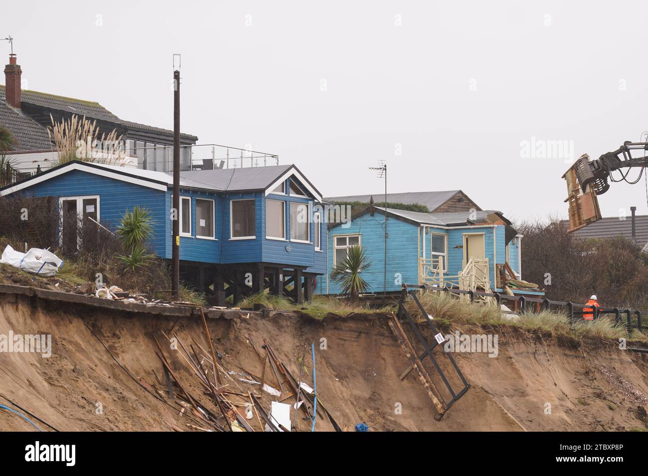 Demolition workers tear down the second of five clifftop homes in the ...