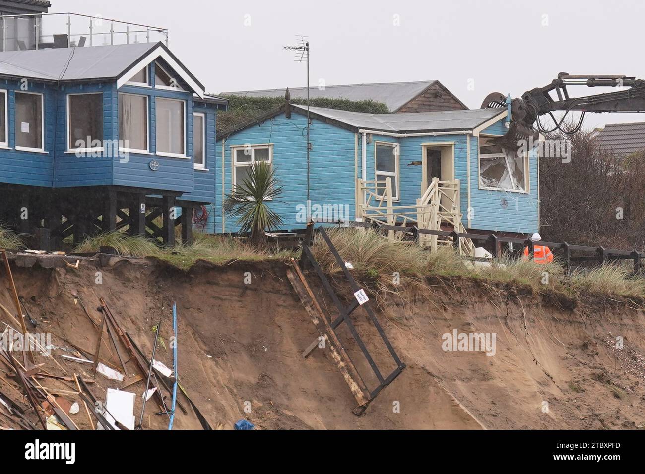 Demolition workers tear down the second of five clifftop homes in the ...