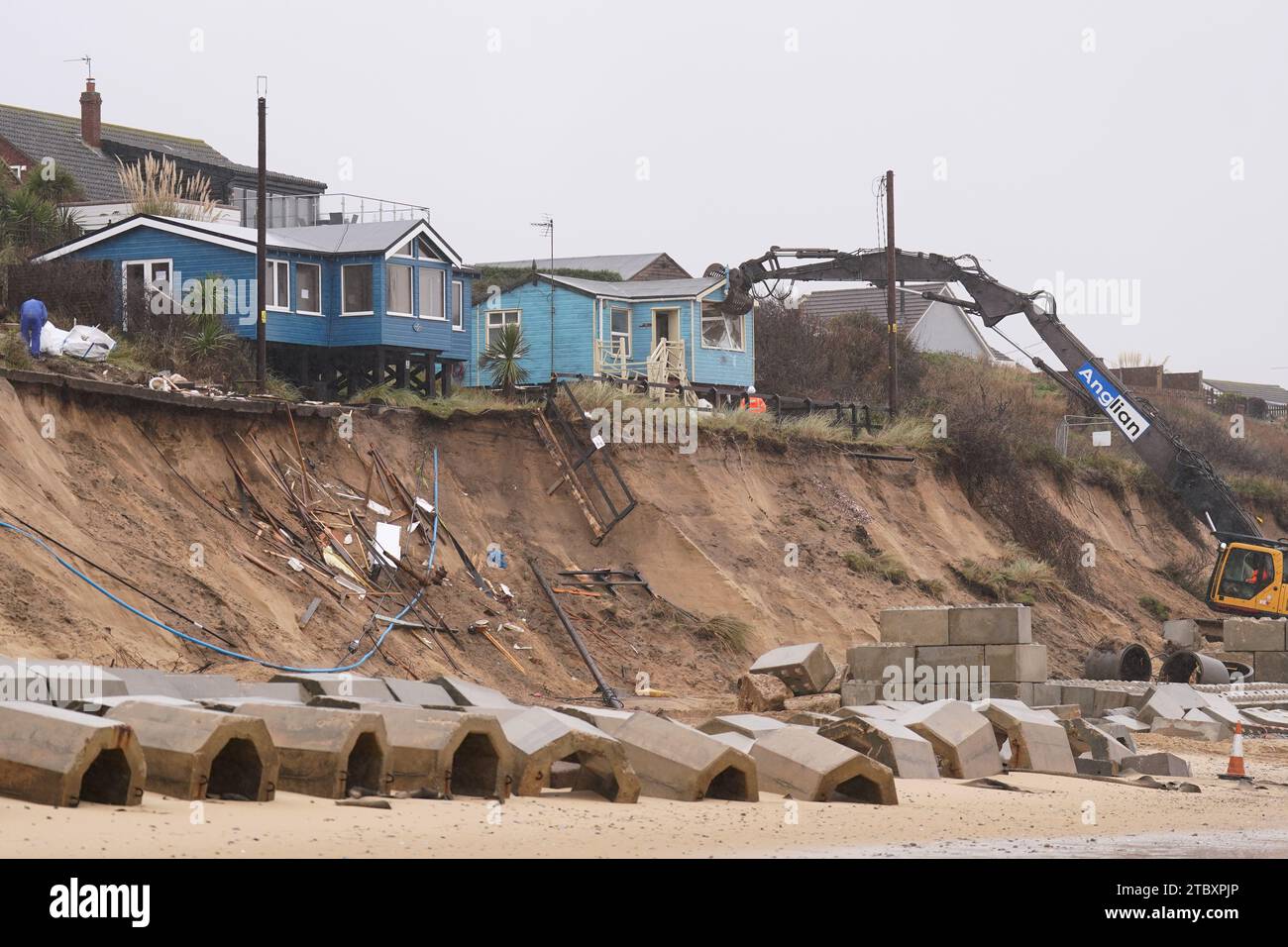 Demolition workers tear down the second of five clifftop homes in the ...