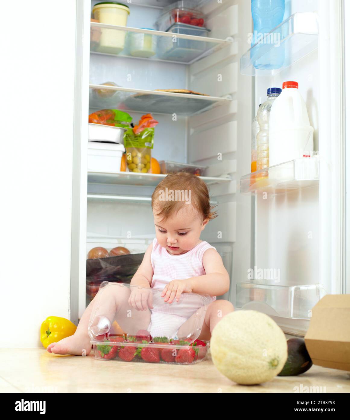 Toddler, little girl and fruit from fridge in kitchen for eating ...