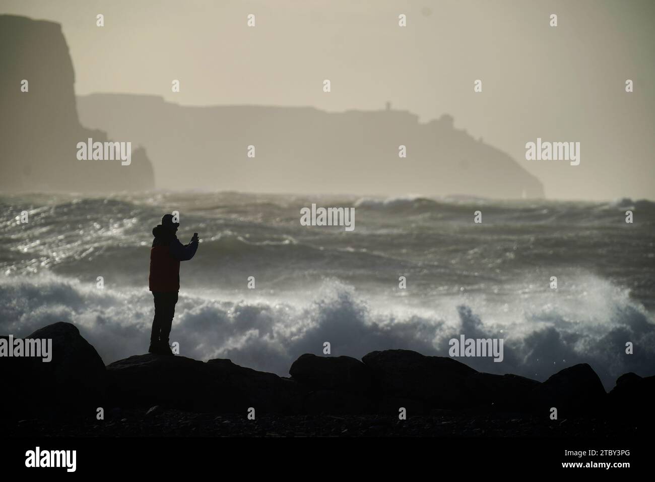 A person watching high waves in Doolin in County Clare on the west ...