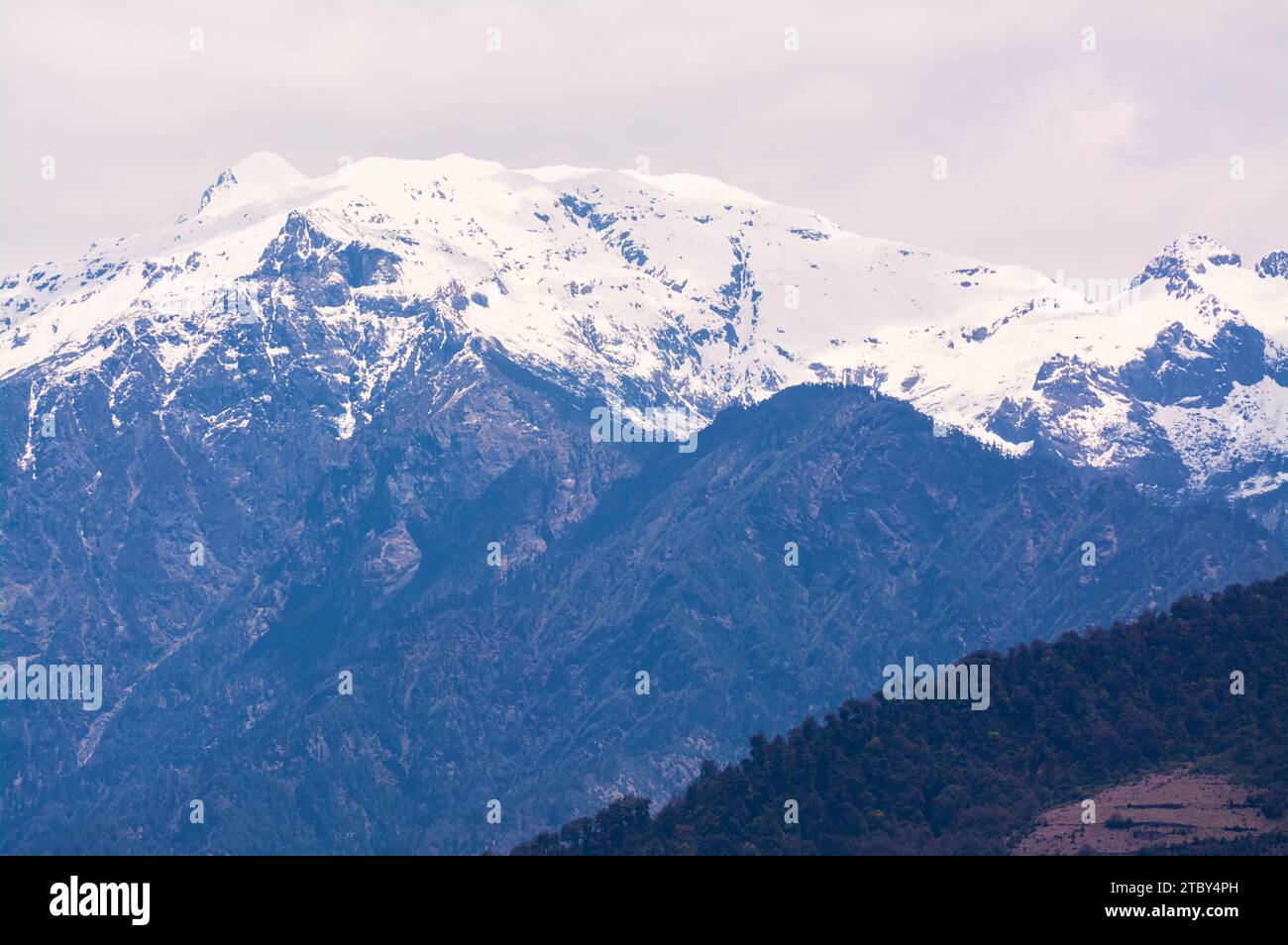 A view of rugged mountains with snow on top from the road between ...