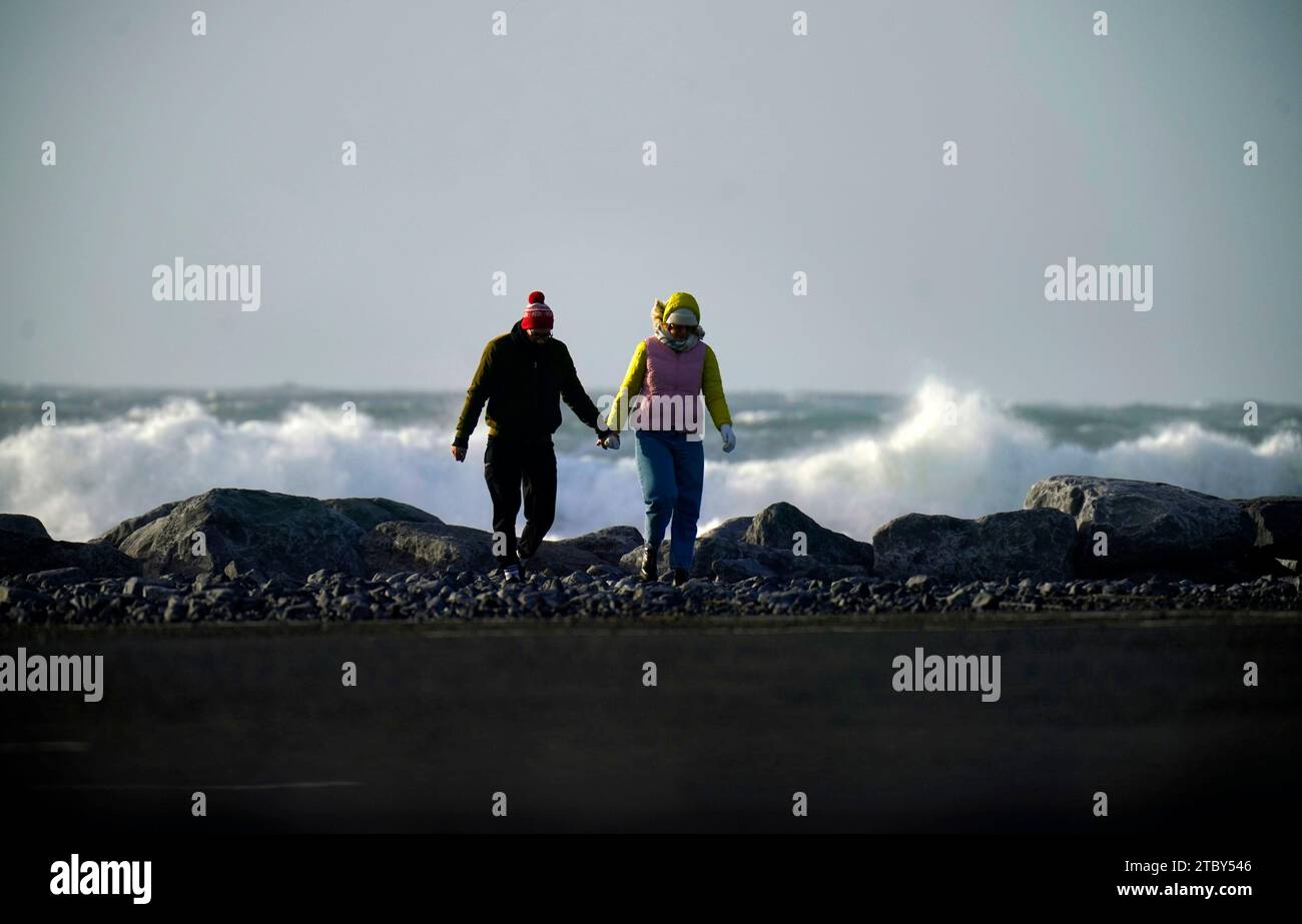 People walk along the seafront in Doolin in County Clare on the west ...