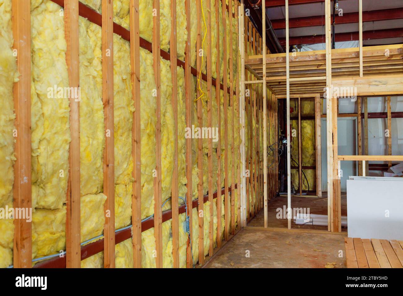 Installing mineral rock wool insulation to walls during new ...