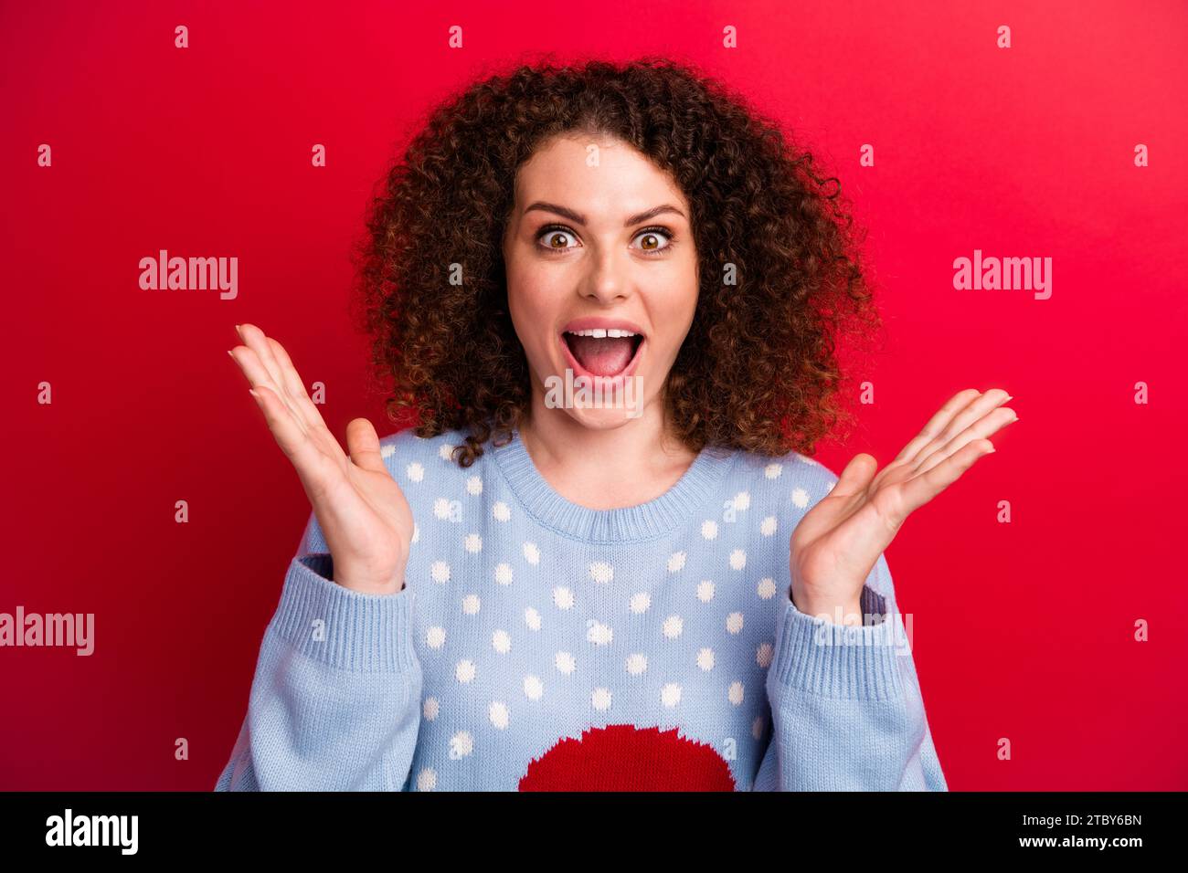 Portrait of girl raised palms up in blue ugly sweater she wear every ...