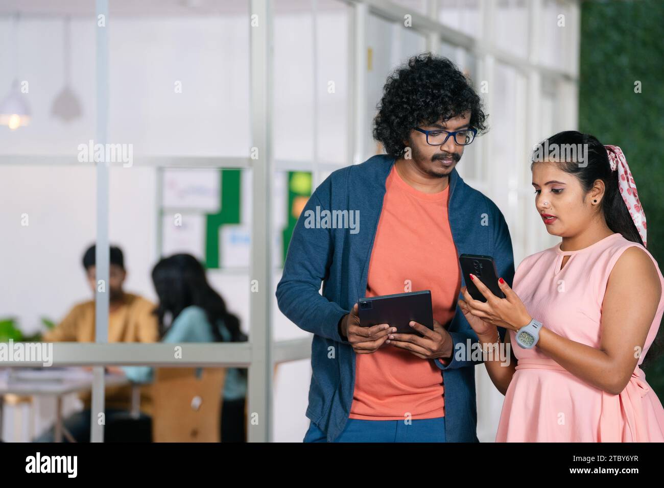 Two colleagues or coworkers at office discussing from tablet and ...