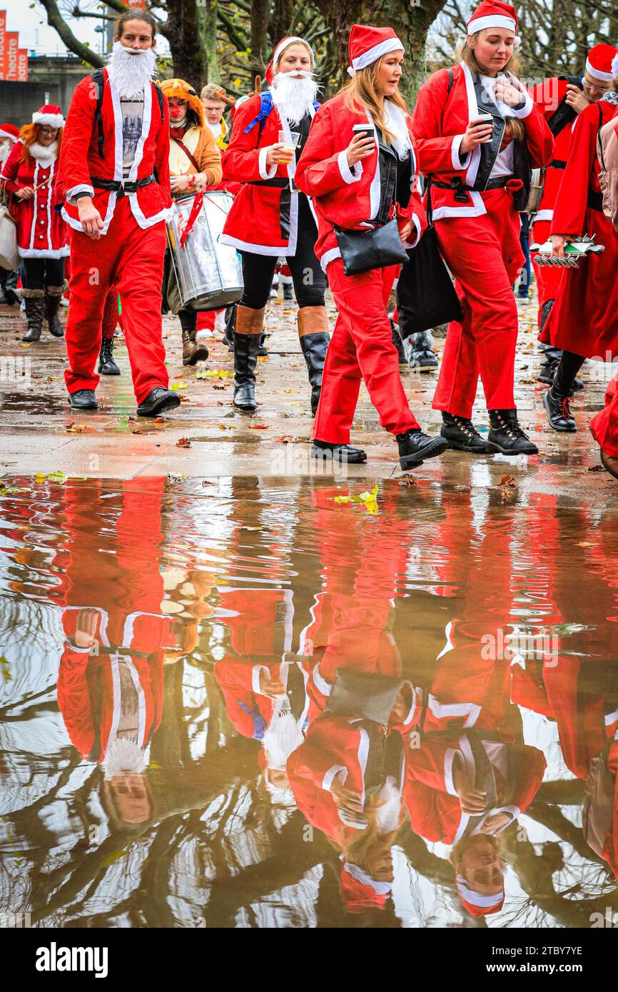 London, UK. 09th Dec, 2023. The santas are reflected in puddles along ...