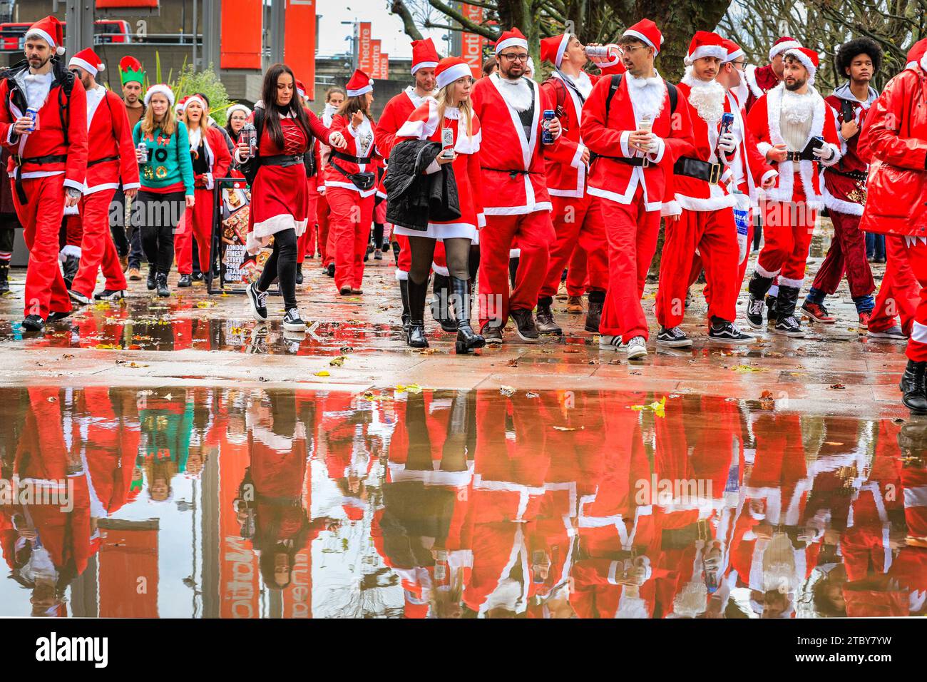 London, UK. 09th Dec, 2023. The santas are reflected in puddles along ...
