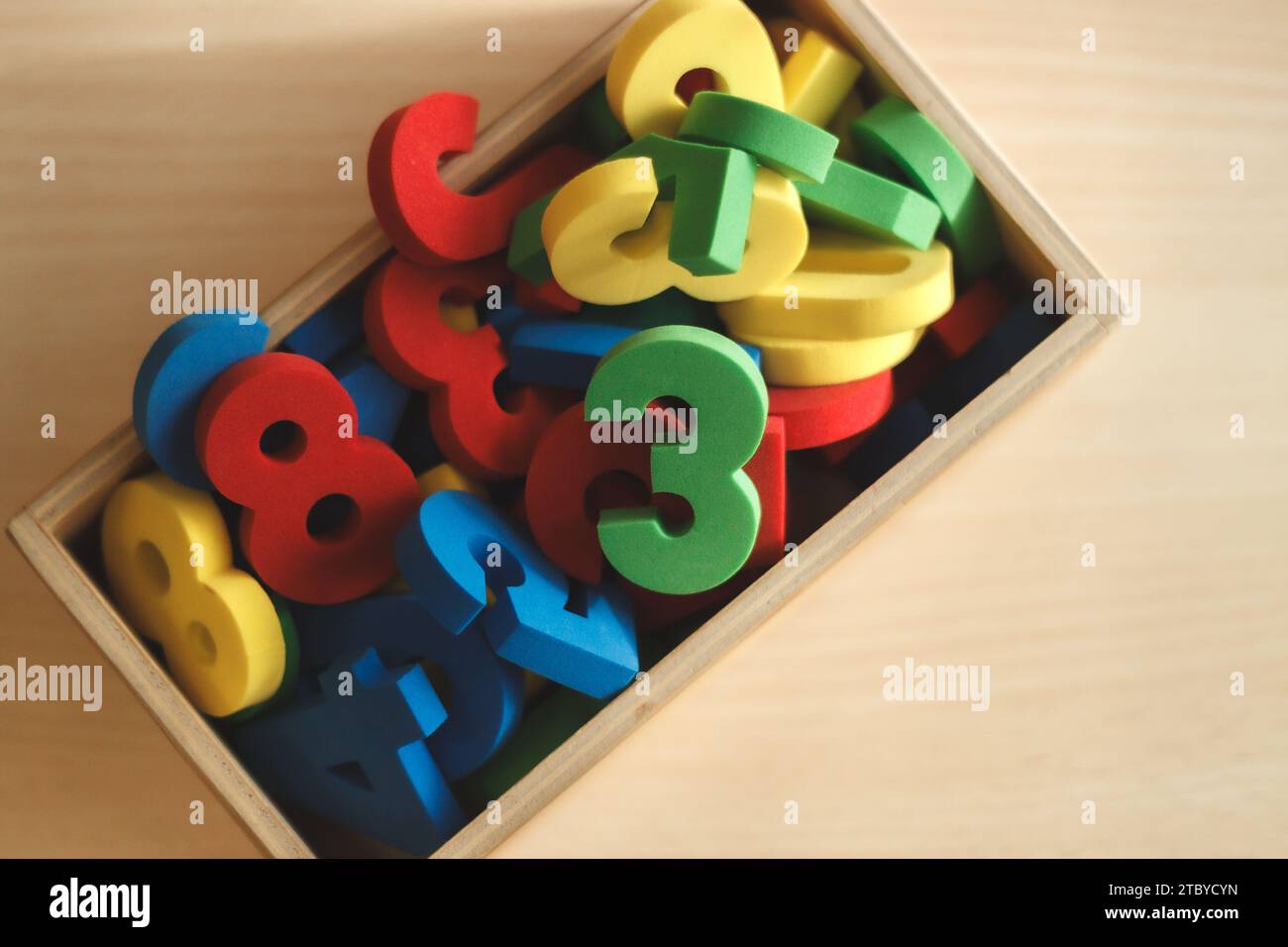 Top view of wooden box filled with colorful numbers, used for children ...