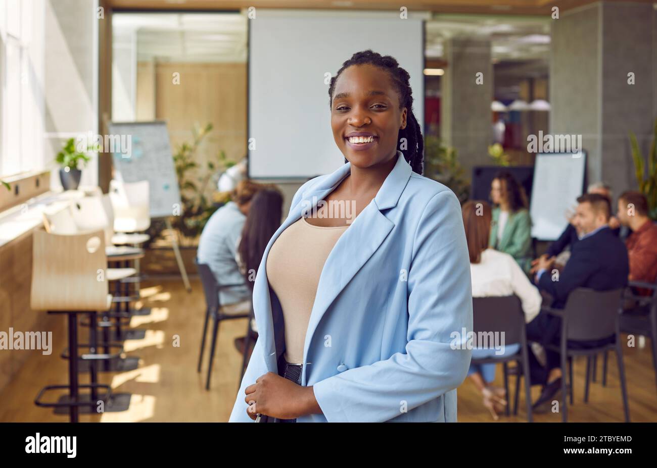 Portrait of beautiful, confident and successful dark-skinned business woman who poses in office ...