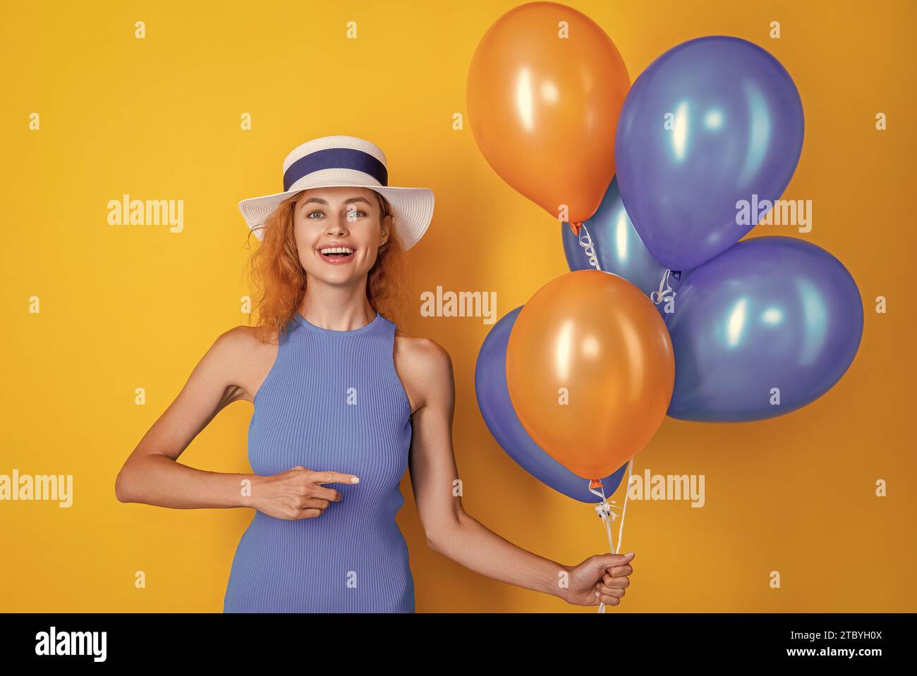 woman with balloons at summer birthday, pointing finger. woman with ...