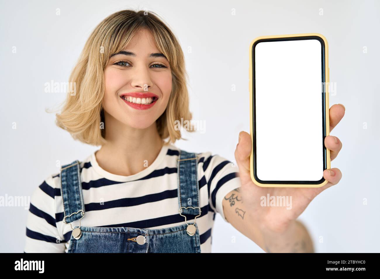 Happy young gen z blonde woman showing big mockup phone screen isolated ...