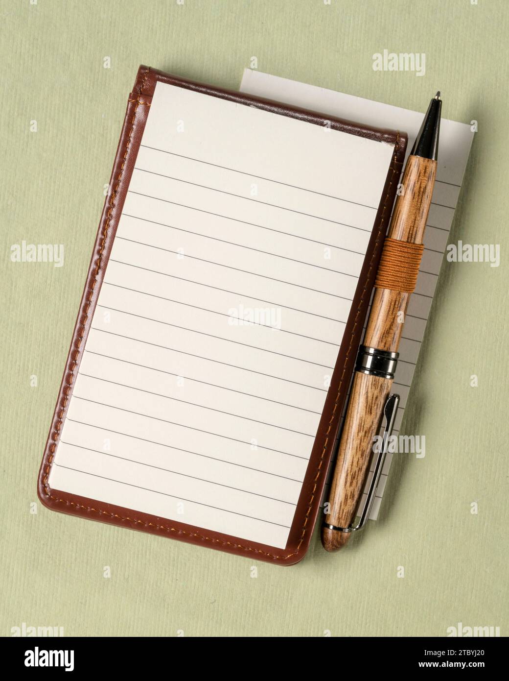 blank sheet of ruled paper in a small journal with a luxury pen against ...