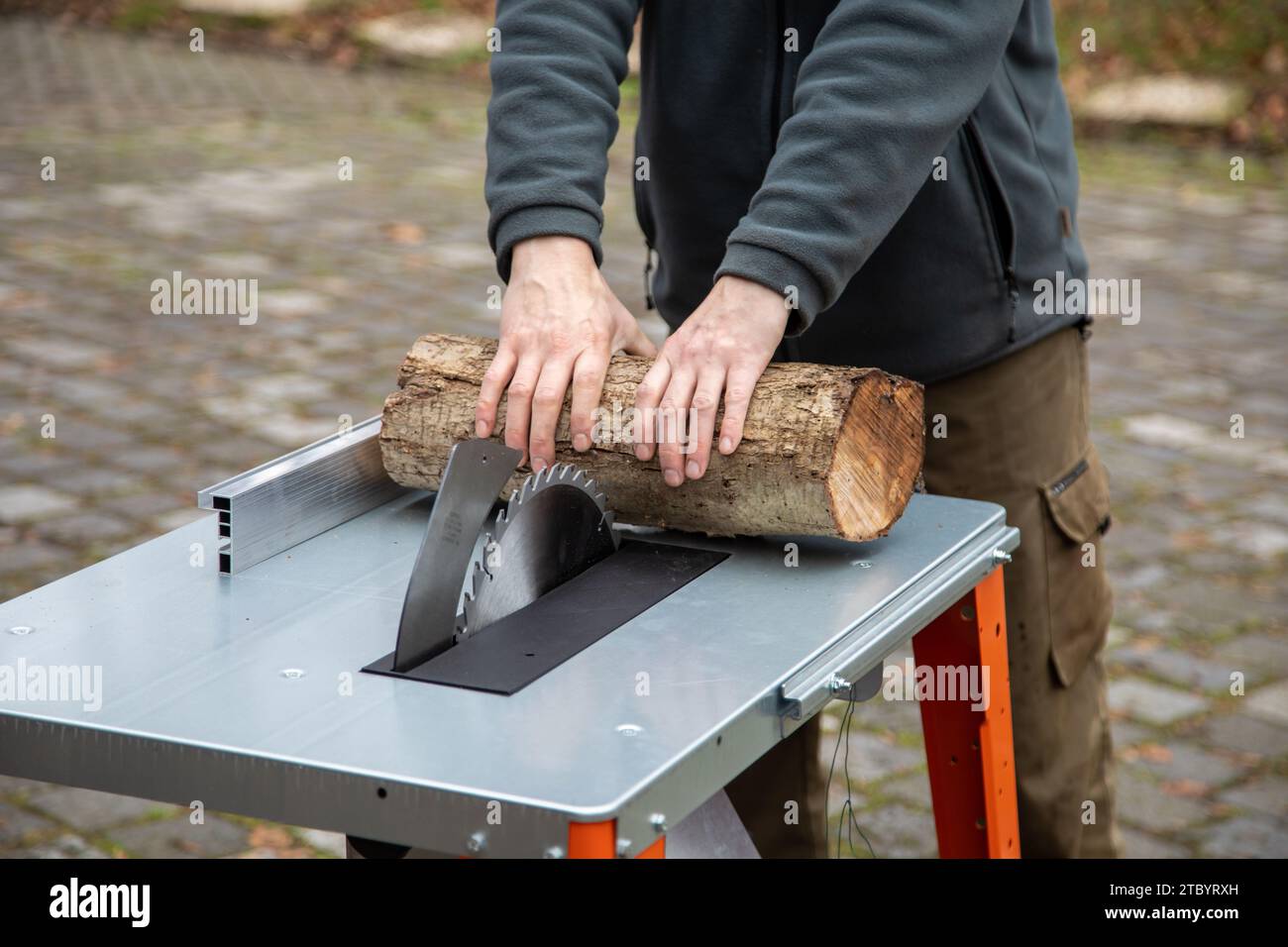 Holzstamm mit einer Kreissäge in zwei Teile sägen Stock Photo - Alamy
