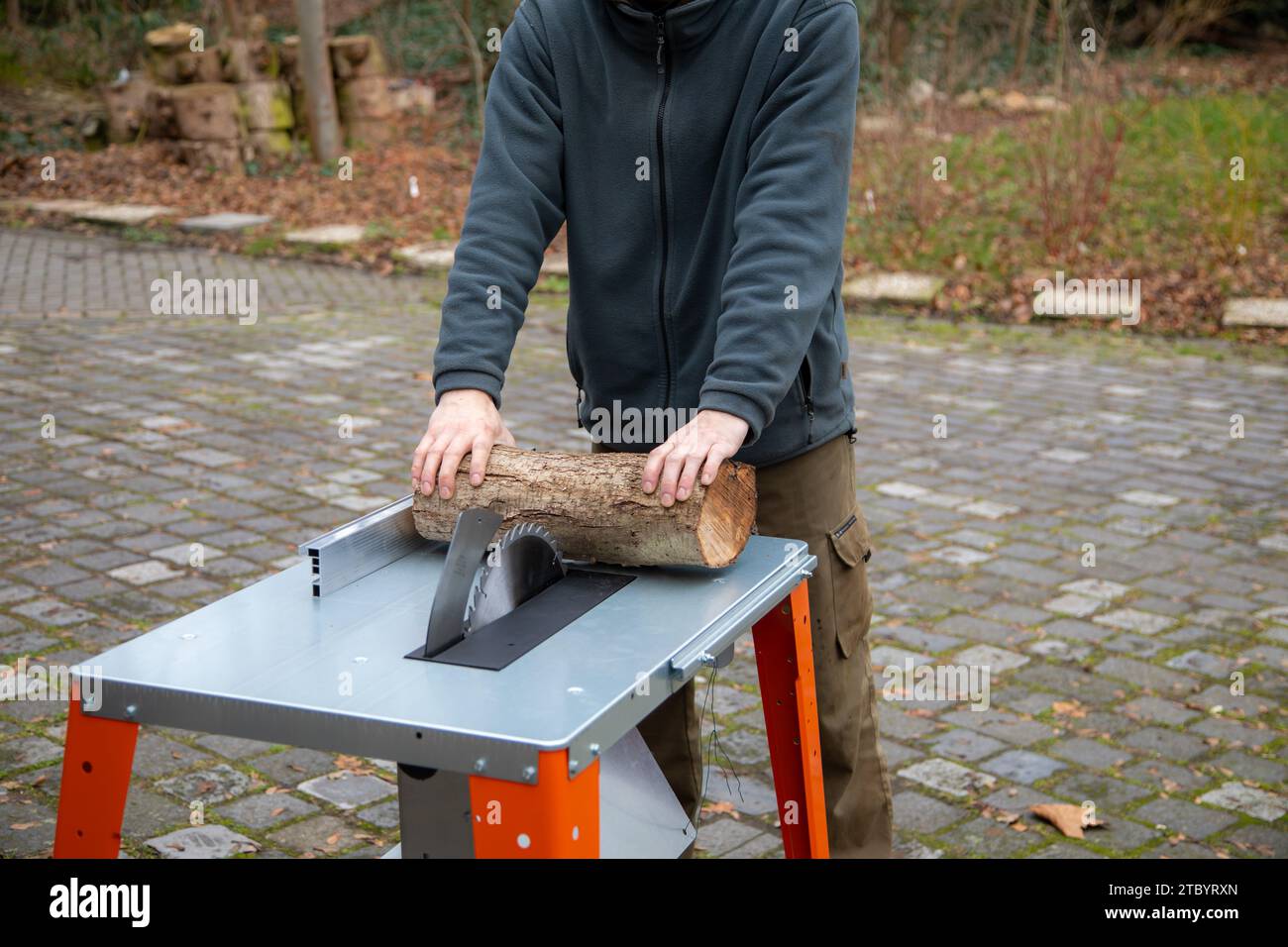 Holzstamm mit einer Kreissäge in zwei Teile sägen Stock Photo - Alamy