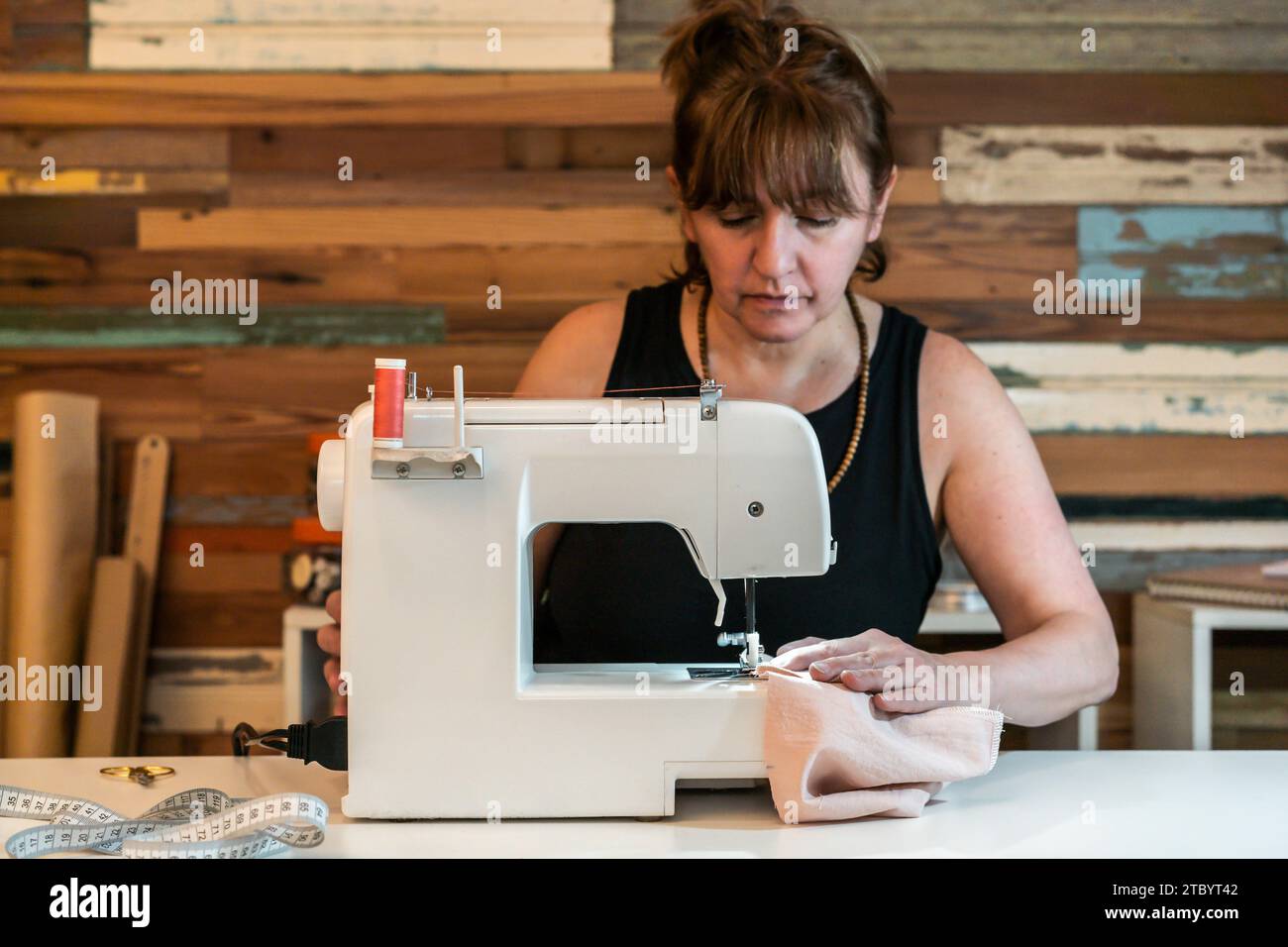 Fashion designer using sewing machine at her studio Stock Photo - Alamy