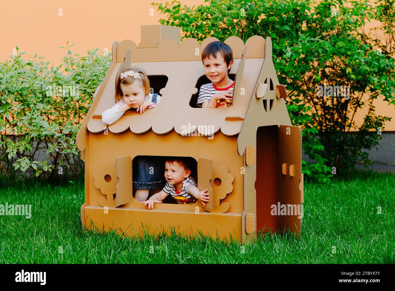 Children are playing in cardboard kid house. Child having fun outdoors ...