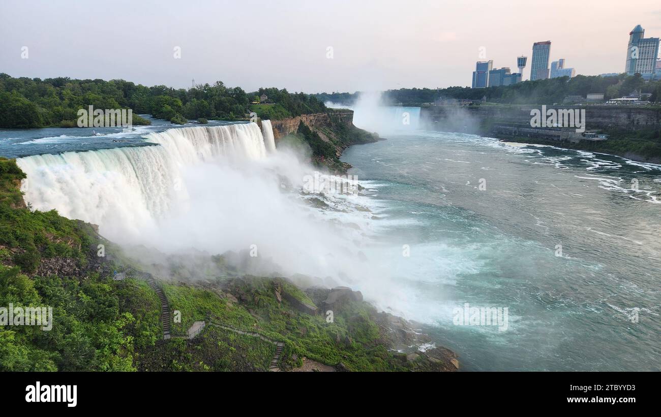 A scenic view of Niagara Falls with lush foliage and nearby buildings ...