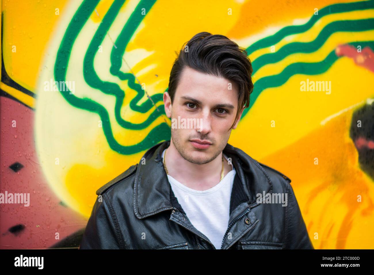 A man standing in front of a colorful wall Stock Photo - Alamy