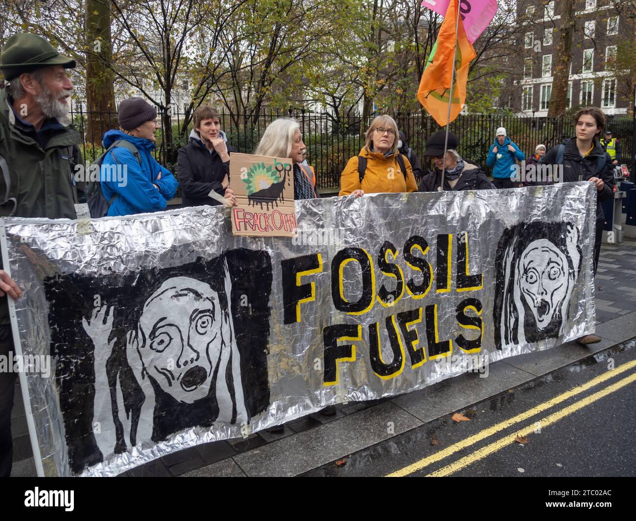 London, UK. 9 Dec 2023. A 'Scream' banner expresses horrot at Fossil ...