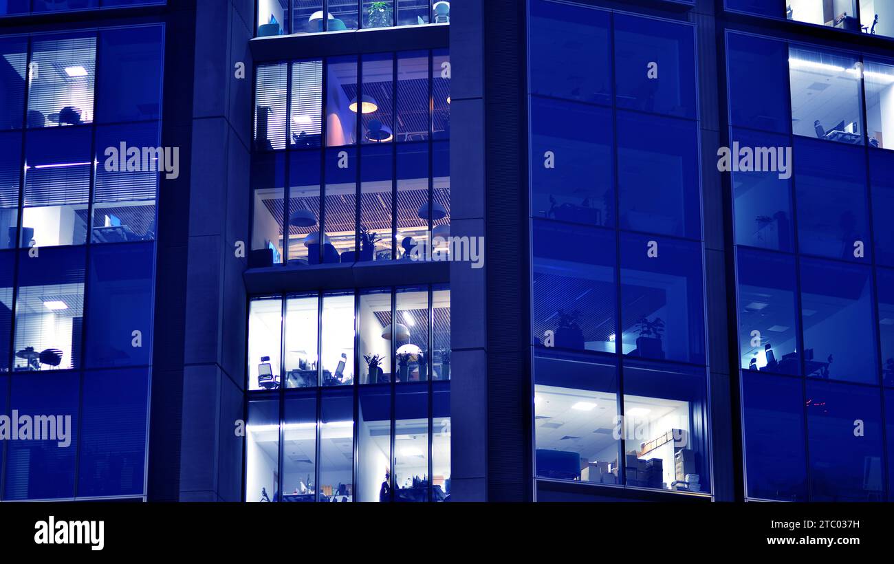 Fragment of the glass facade of a modern corporate building at night ...