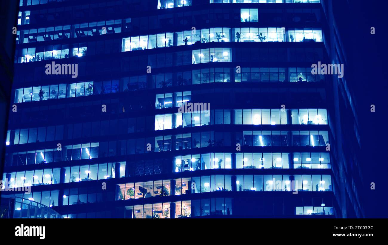 Fragment of the glass facade of a modern corporate building at night ...