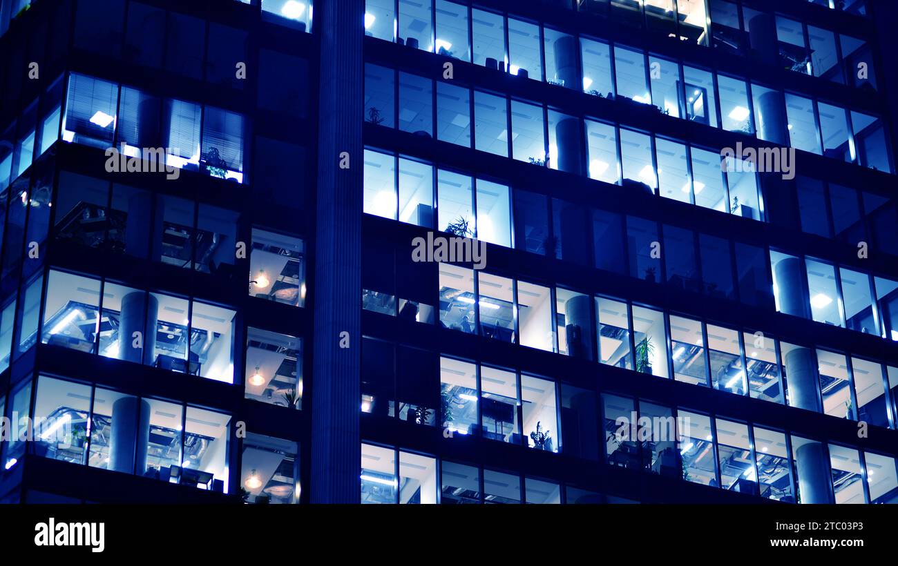 Fragment of the glass facade of a modern corporate building at night ...