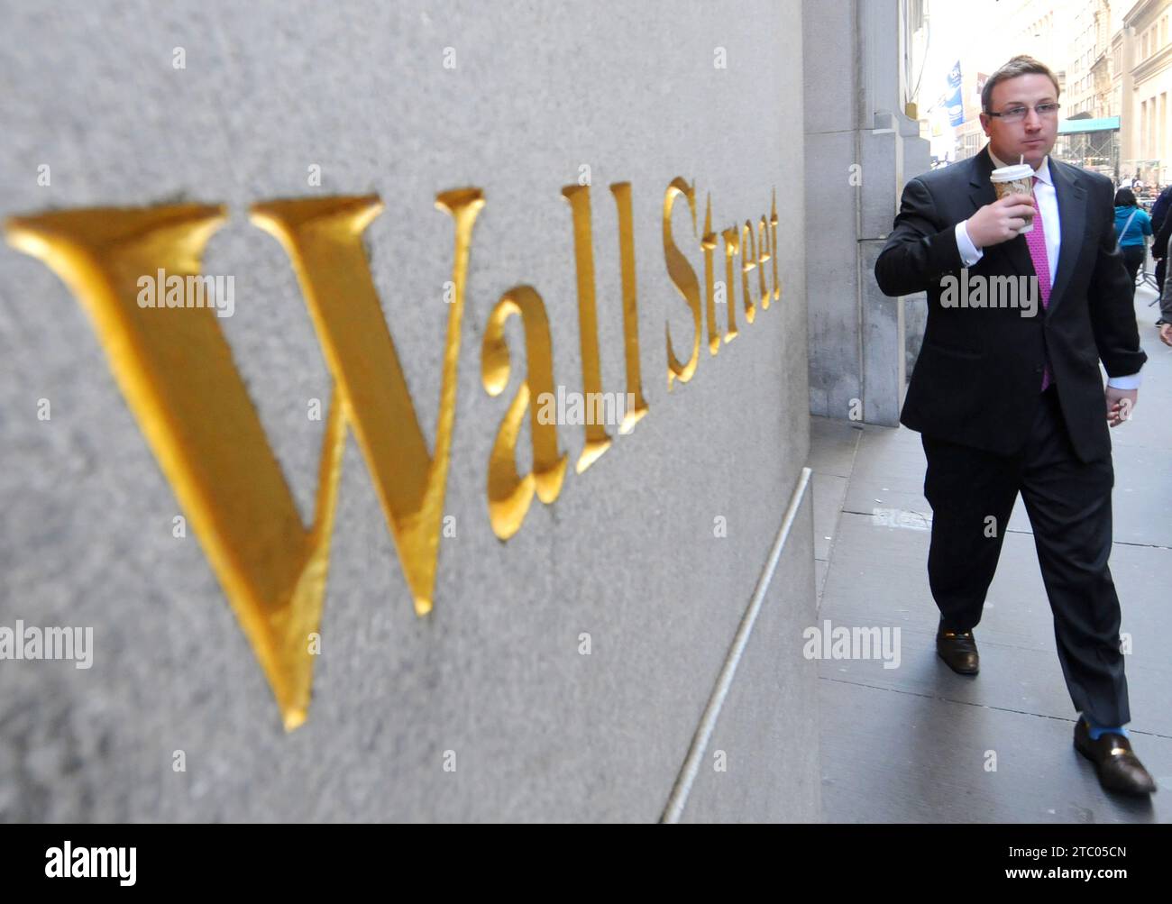 New York, USA - NOV 07, 2011. A man passes by Wall Street sign-mark ...
