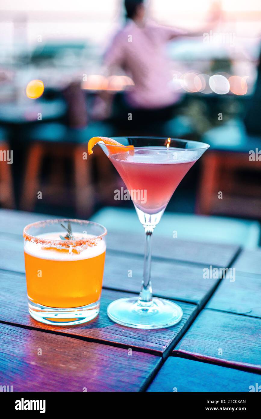 The two colorful cocktails on a wooden table of a bar Stock Photo - Alamy