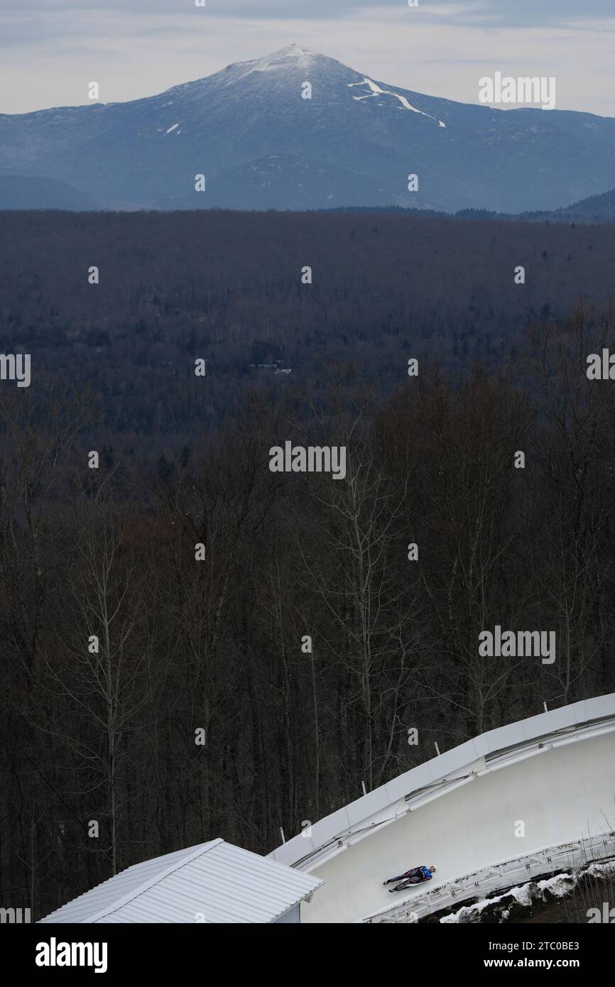 Franceska Bona, of Latvia, takes a curve as Whiteface Mountain is seen ...