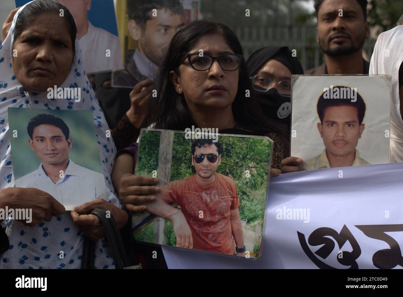 Dhaka, Bangladesh. 10th Dec, 2023. Relatives hold pictures of missing family members as they ...