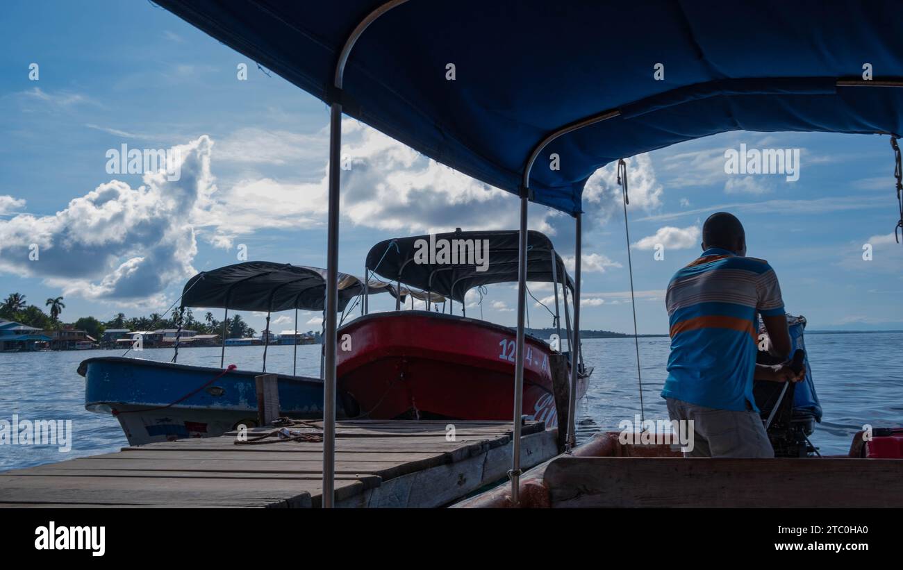 Boat driver starting engine of his water taxi, water taxi with canopy ...