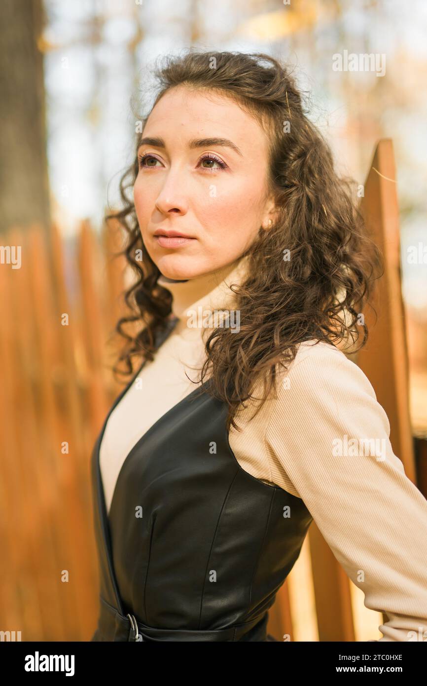 Autumn portrait of a beautiful happy curly woman in fall season copy ...