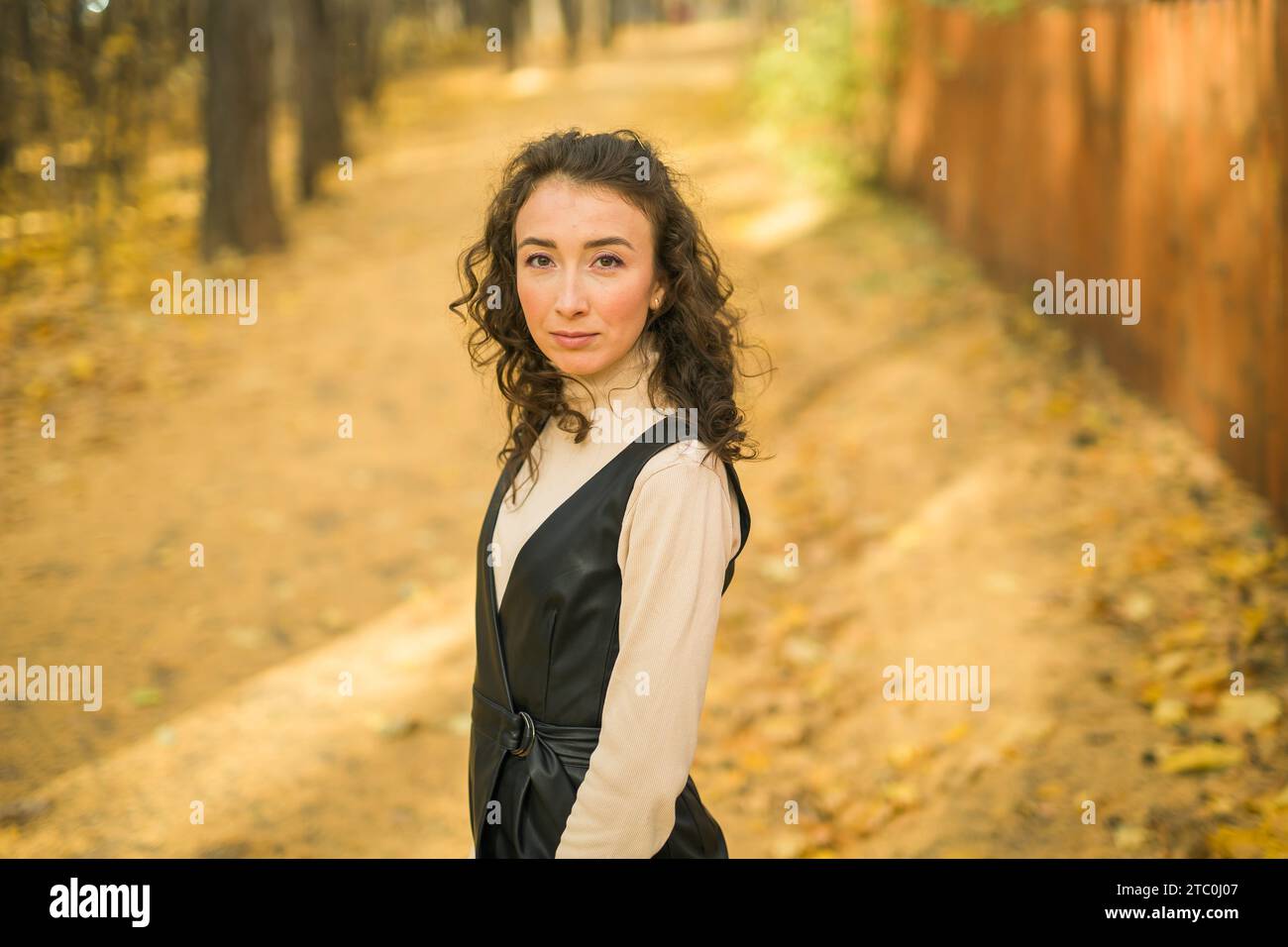 Autumn portrait of a beautiful happy curly woman in fall season copy ...